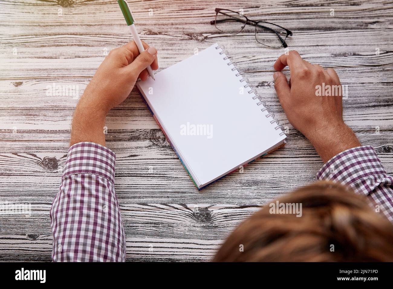 Man writing in notepad mock up, using his left hand. Conceptual photo ...