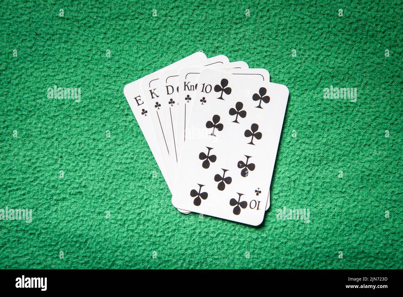A royal straight flush poker playing cards isolated on a green ...