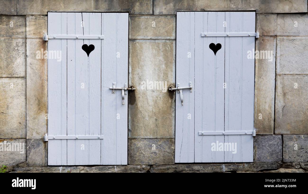 The two white locked doors with heart-shaped holes Stock Photo - Alamy