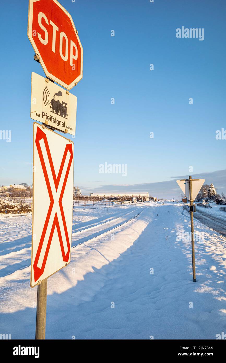 A vertical shot of a stop traffic sign on a pole near the railroad in ...