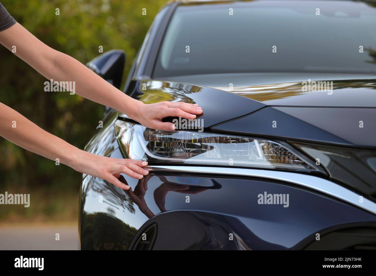 Female driver hands checking headlight of her new car. Purchase of ...