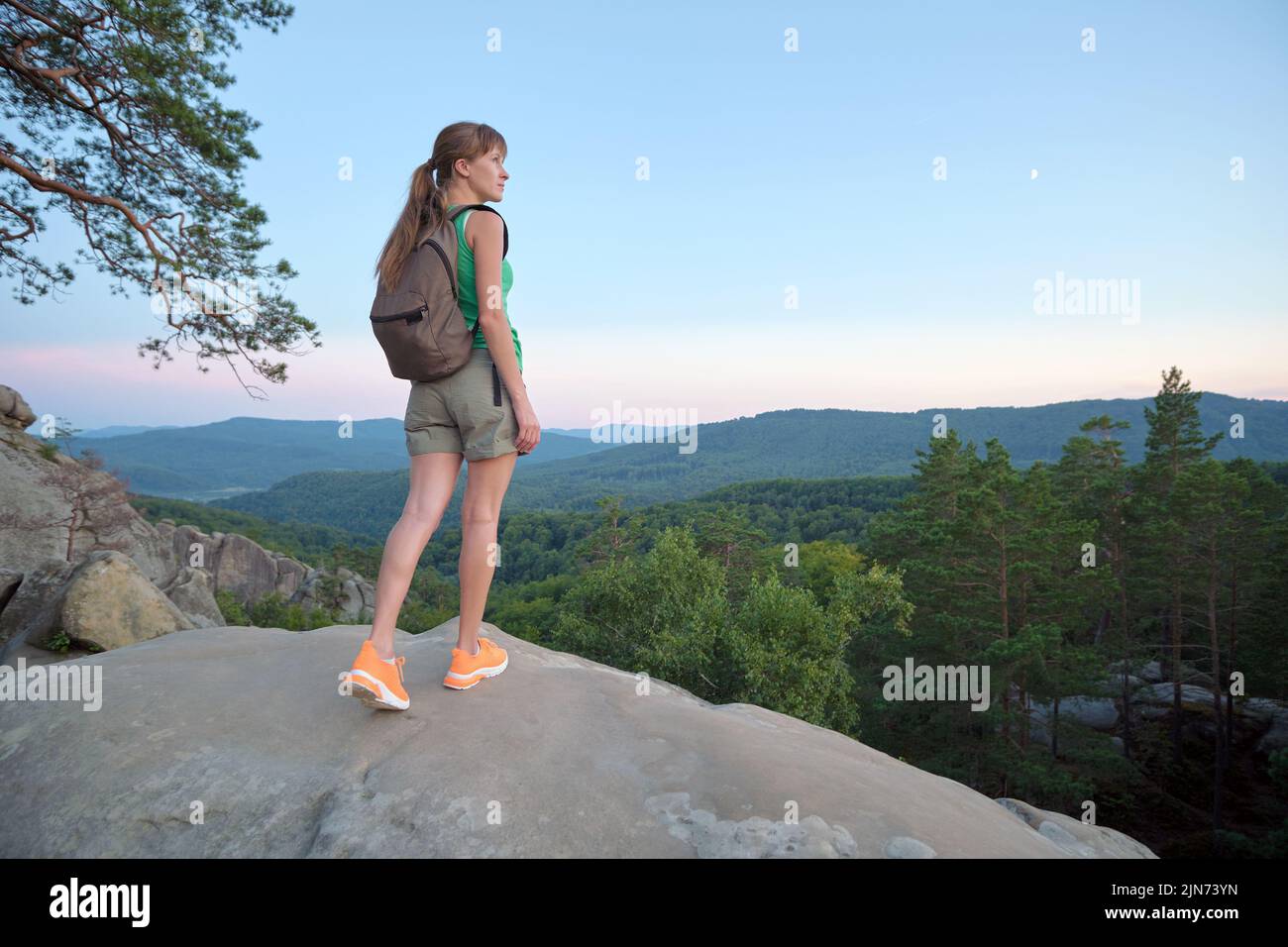 Hiker woman walking on mountain footpath enjoying evening nature ...