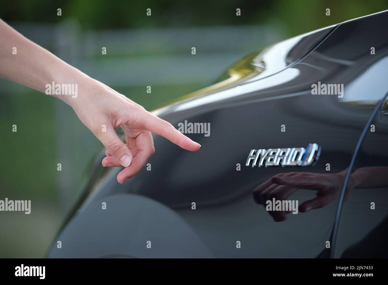 Human hand showing hybrid car sign on new effective vehicle Stock Photo ...