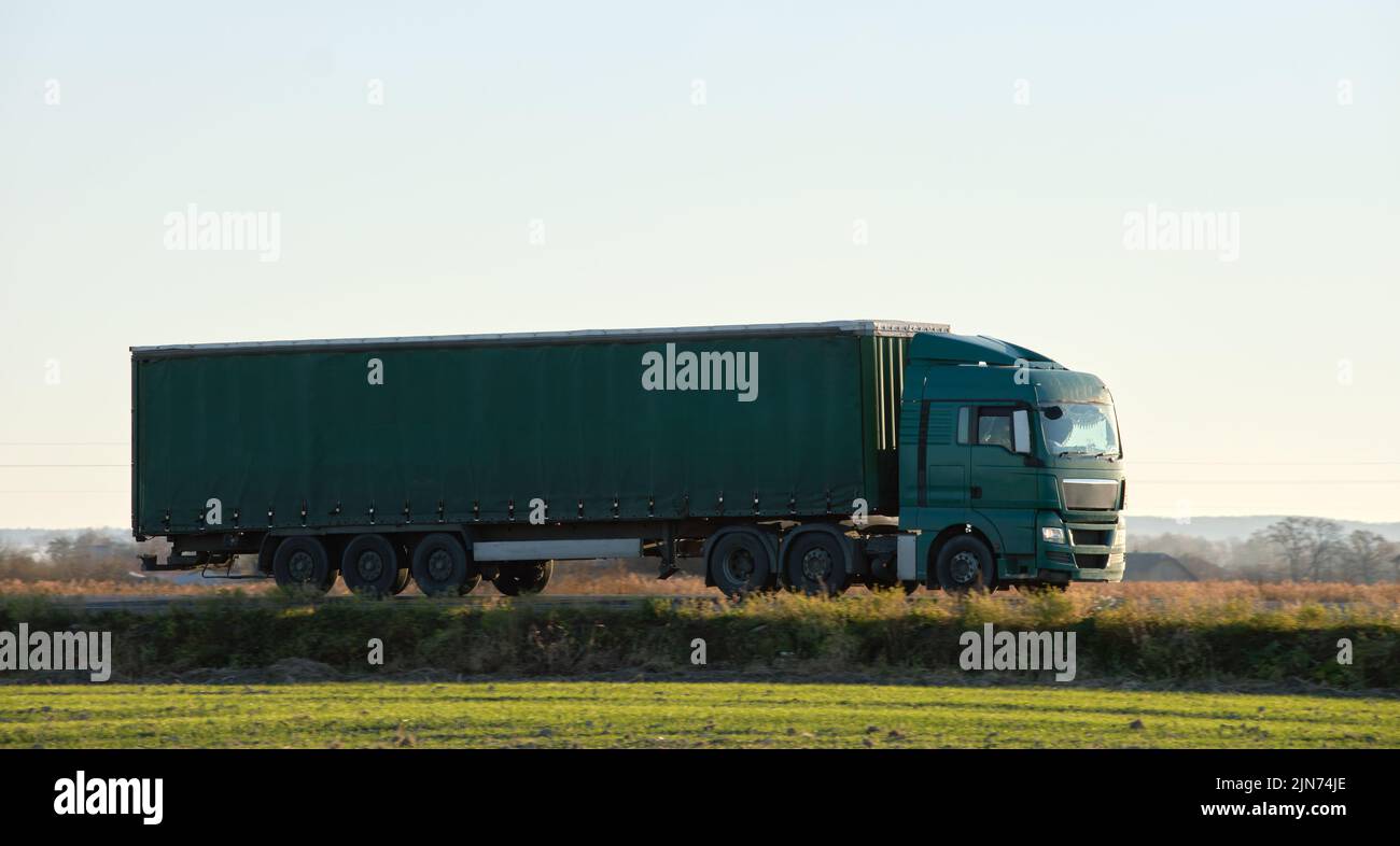 Semi-truck with cargo trailer driving on highway hauling goods in ...