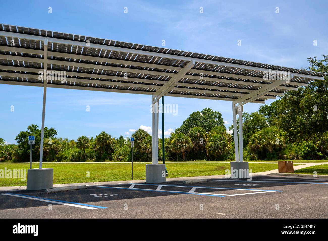Solar panels installed as shade roof over parking lot for parked ...