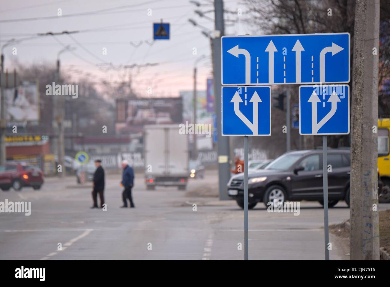 Traffic sign pointing multiple road lanes direction on city street ...