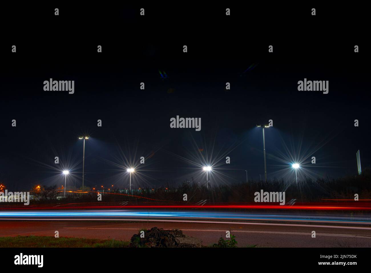 A highway road with light trails of long exposure on a background of ...