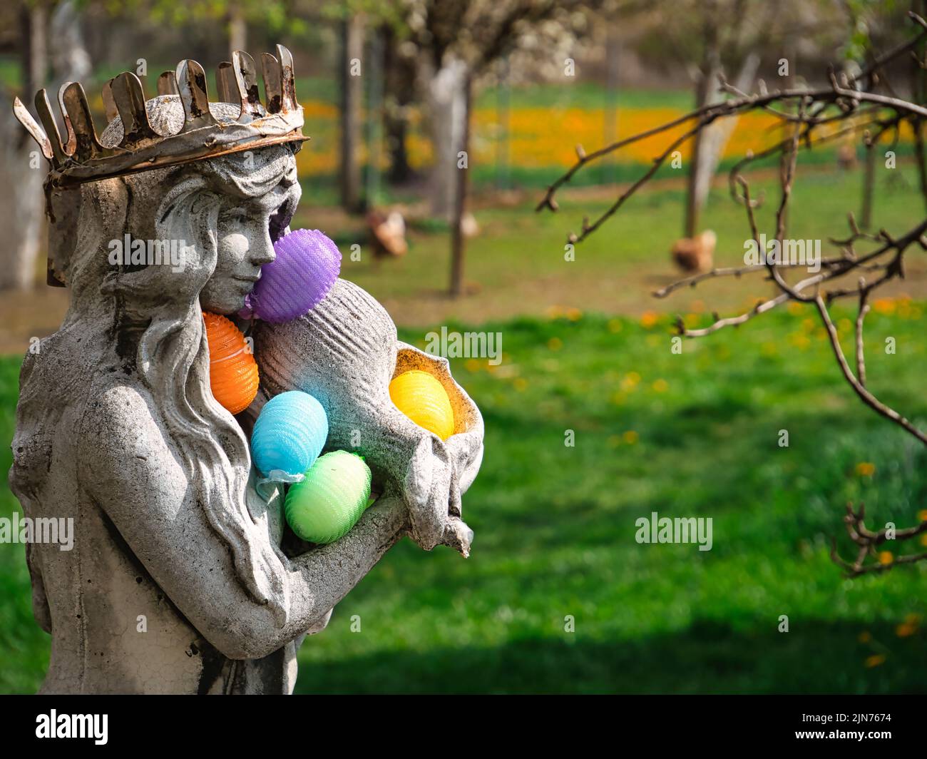 Stone lady statue with rusty crown holding colorful Easter eggs Stock ...