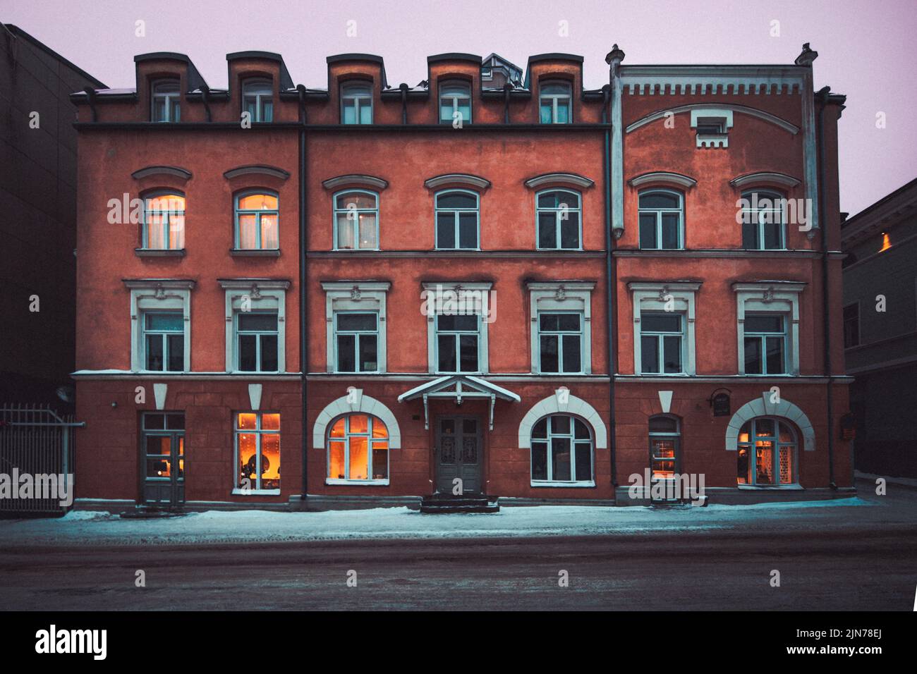 The exterior of an old style red stone building during sunset Stock ...