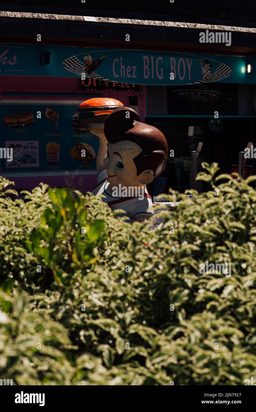 A vertical shot of "Chez Big Boy" fast food restaurant mascot behind a ...