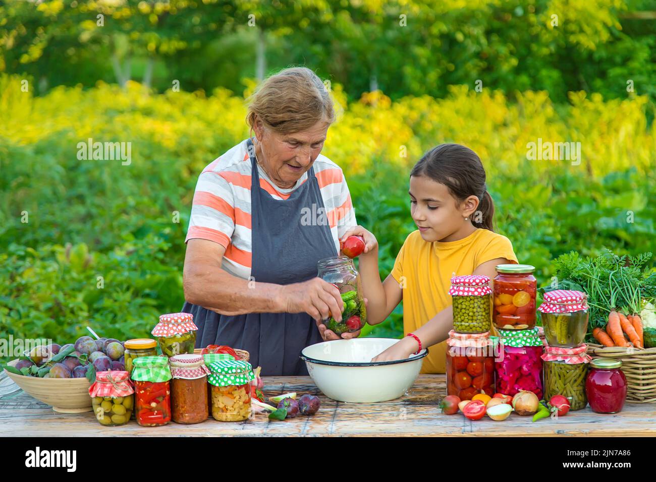 Women with jar preserved vegetables for the winter mother and daughter ...