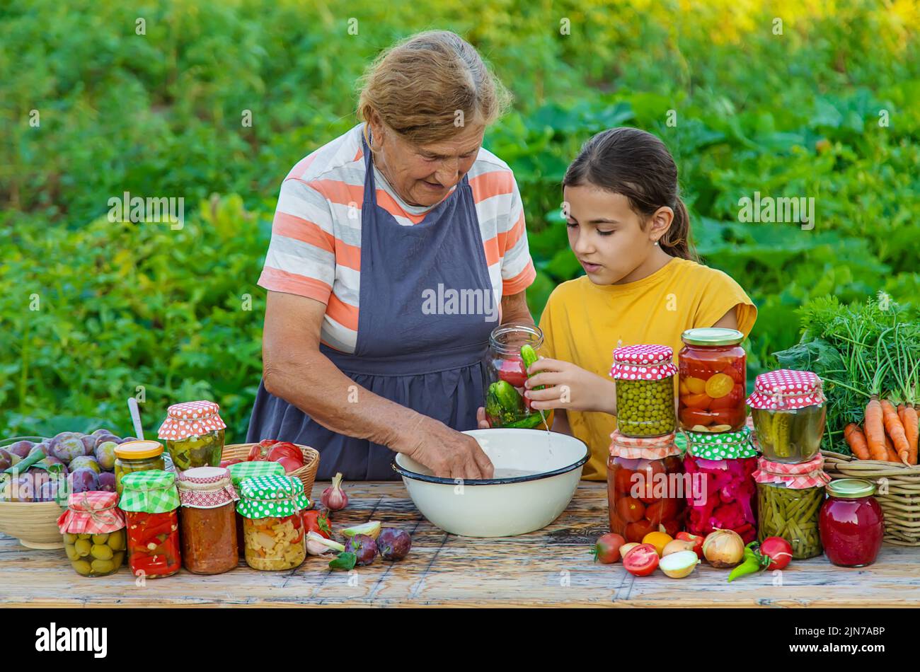 Women with jar preserved vegetables for the winter mother and daughter ...