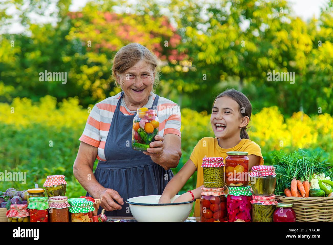 Women with jar preserved vegetables for the winter mother and daughter ...
