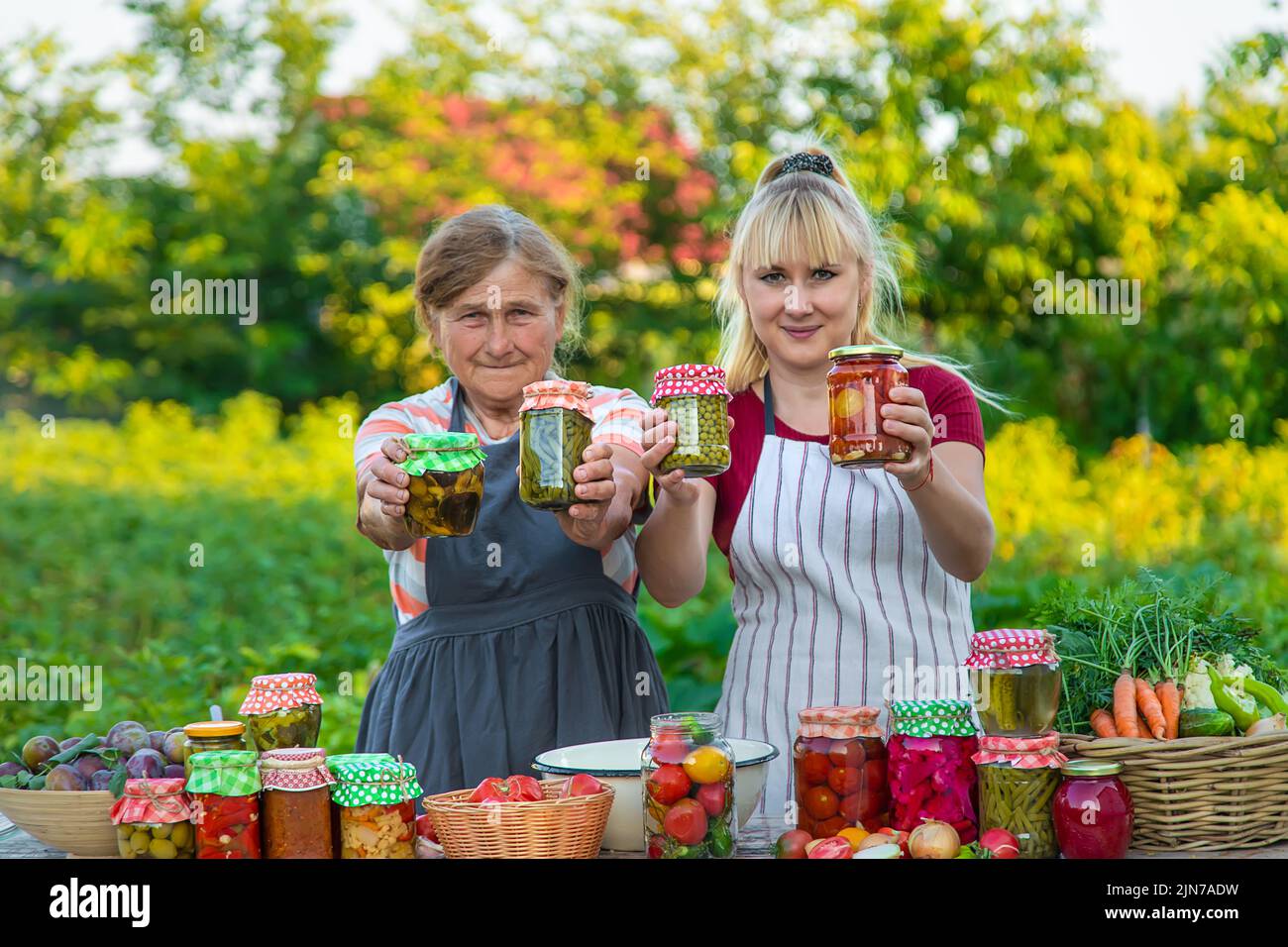 Women with jar preserved vegetables for the winter mother and daughter ...