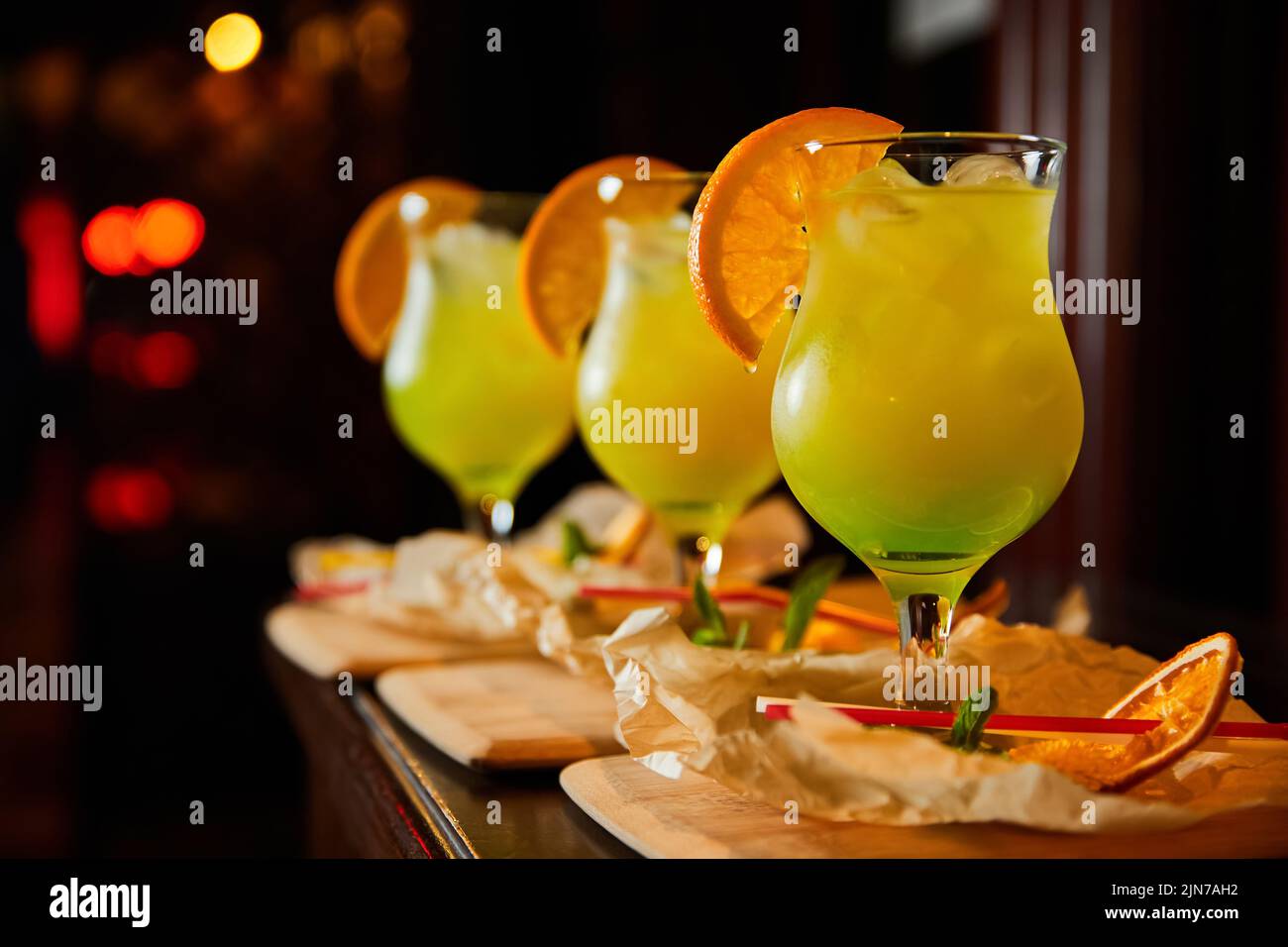 Alcoholic cocktails decorated with half slices of orange on the bar ...