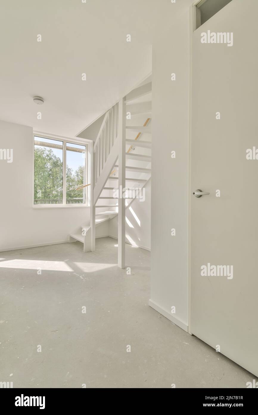 White spiral stairway connecting levels of contemporary house with ...