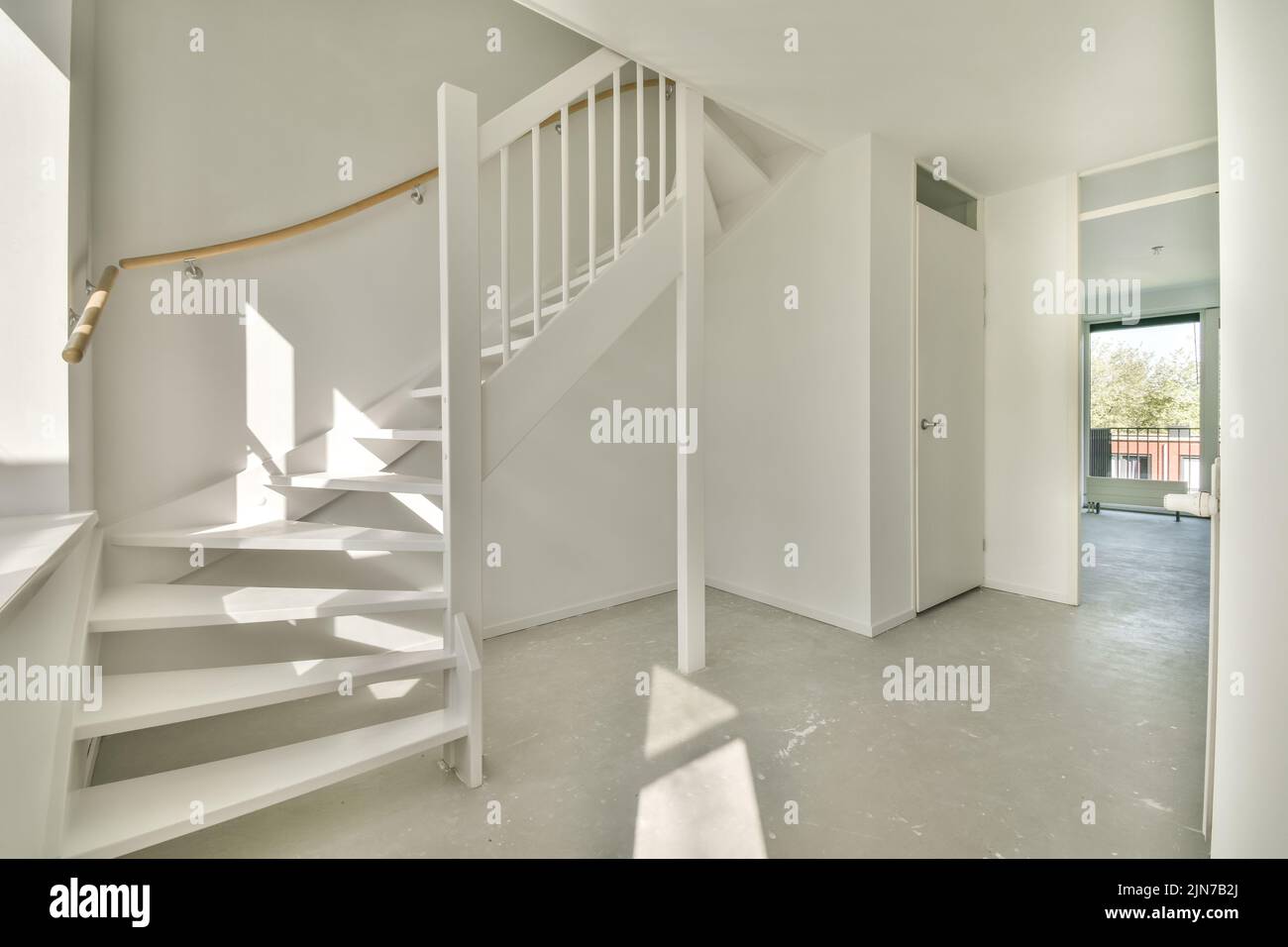 White spiral stairway connecting levels of contemporary house with ...