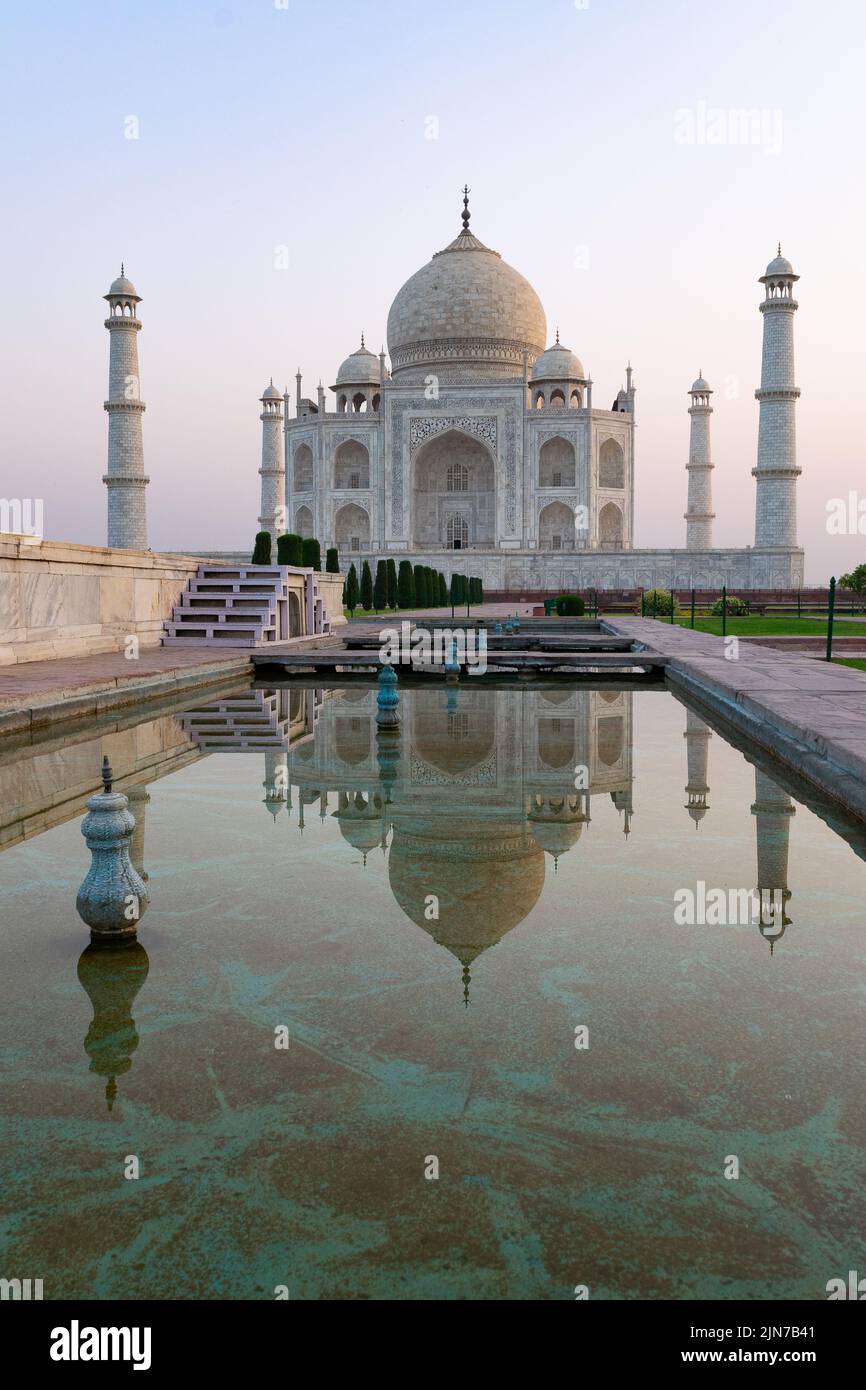 A vertical shot of the Taj Mahal reflecting in the pool of water in ...