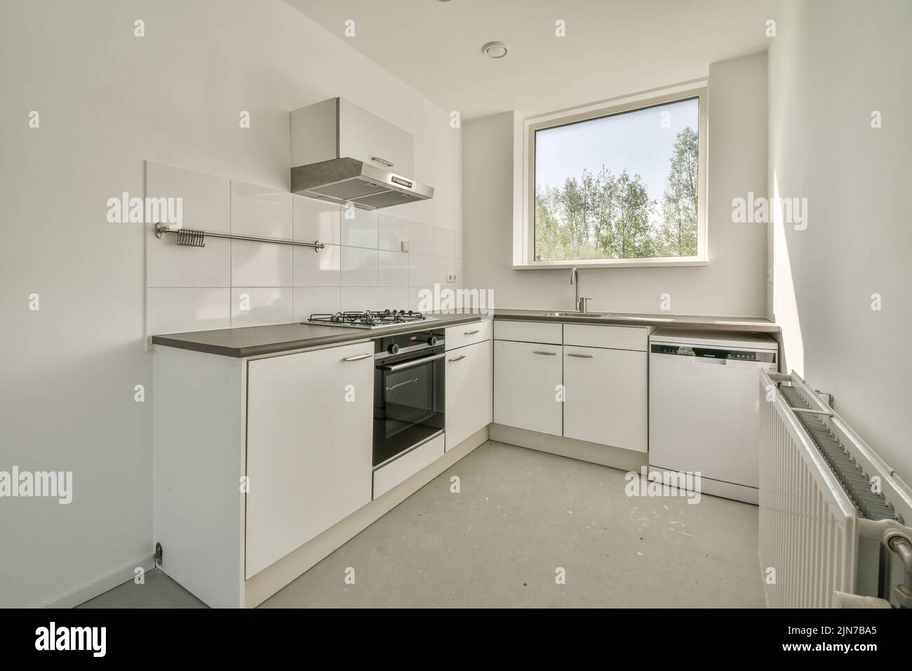 Interior of empty white kitchen with windows and wooden parquet floor ...