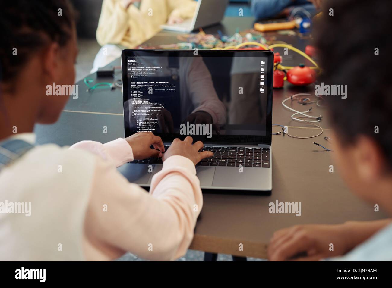 Back view of kids using laptop in engineering class and programming ...