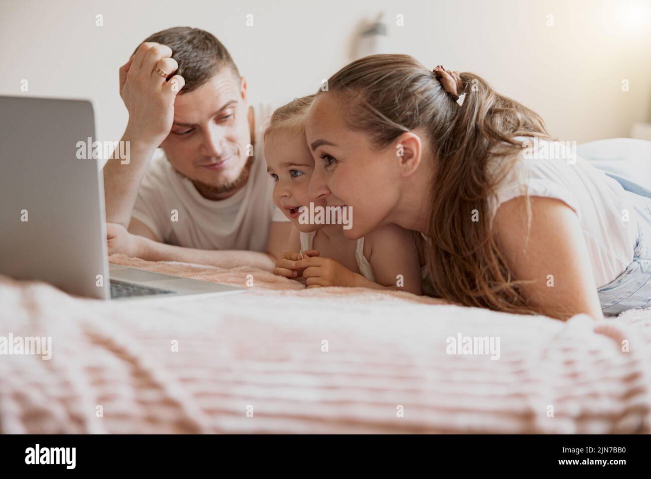 Cheerful family having fun together watching cartoons online on laptop ...