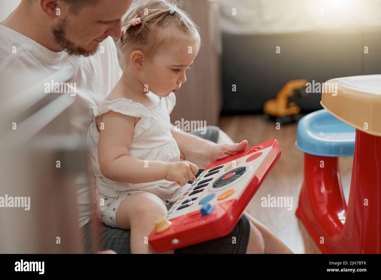 Handsome father with his child playing together using toys at home ...