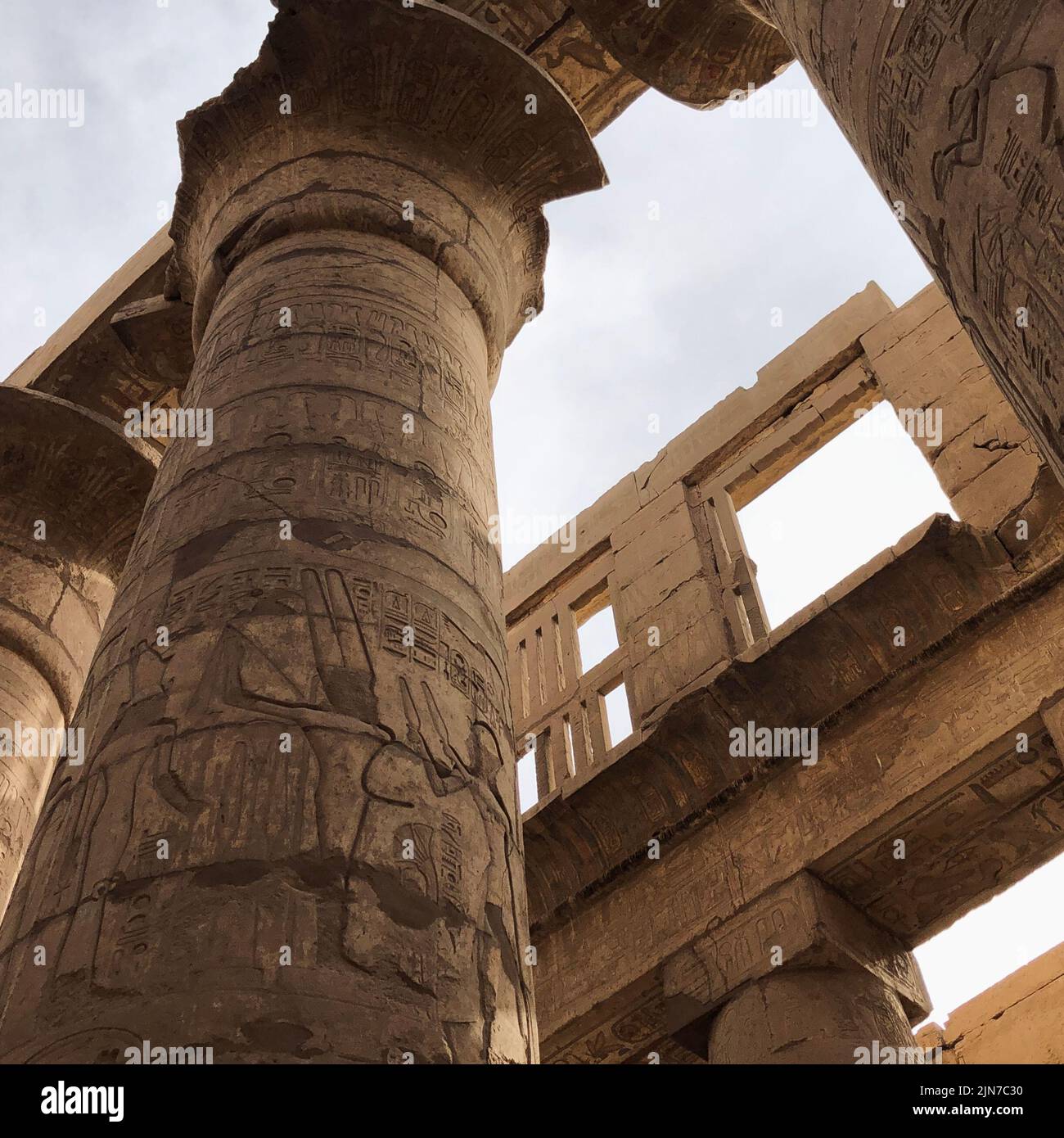 A low angle shot of stone bricks with Egyptian carvings in Luxor Temple ...