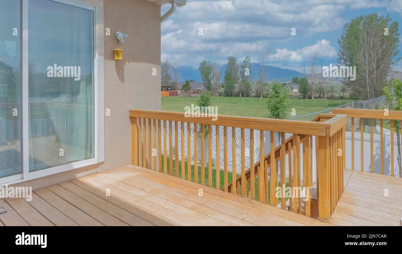 Panorama White puffy clouds Wooden deck of a fenced house with sliding ...