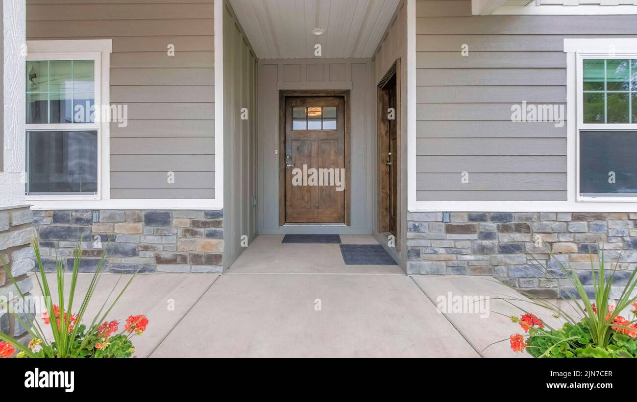 Panorama Porch of a house with potted flowers and two wooden front ...
