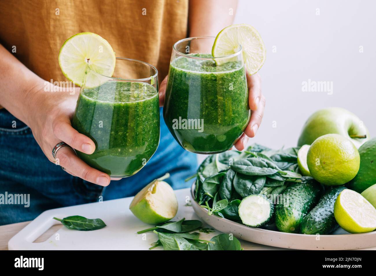 Female hands hold a glass of freshly made green smoothie, selective ...