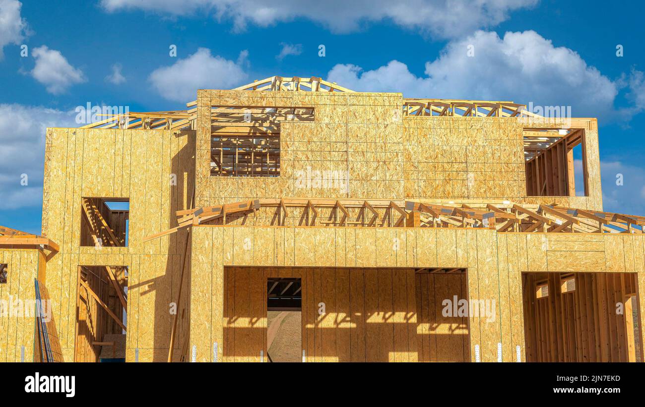 Panorama White puffy clouds Unfinished house structure with timber ...