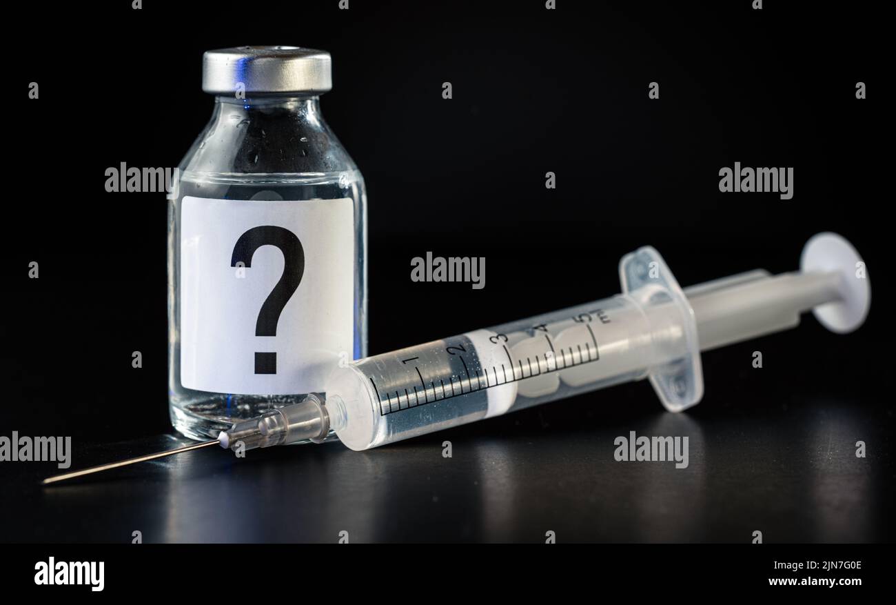 Vaccine bottle with hypodermic syringe needle near, question mark on ...