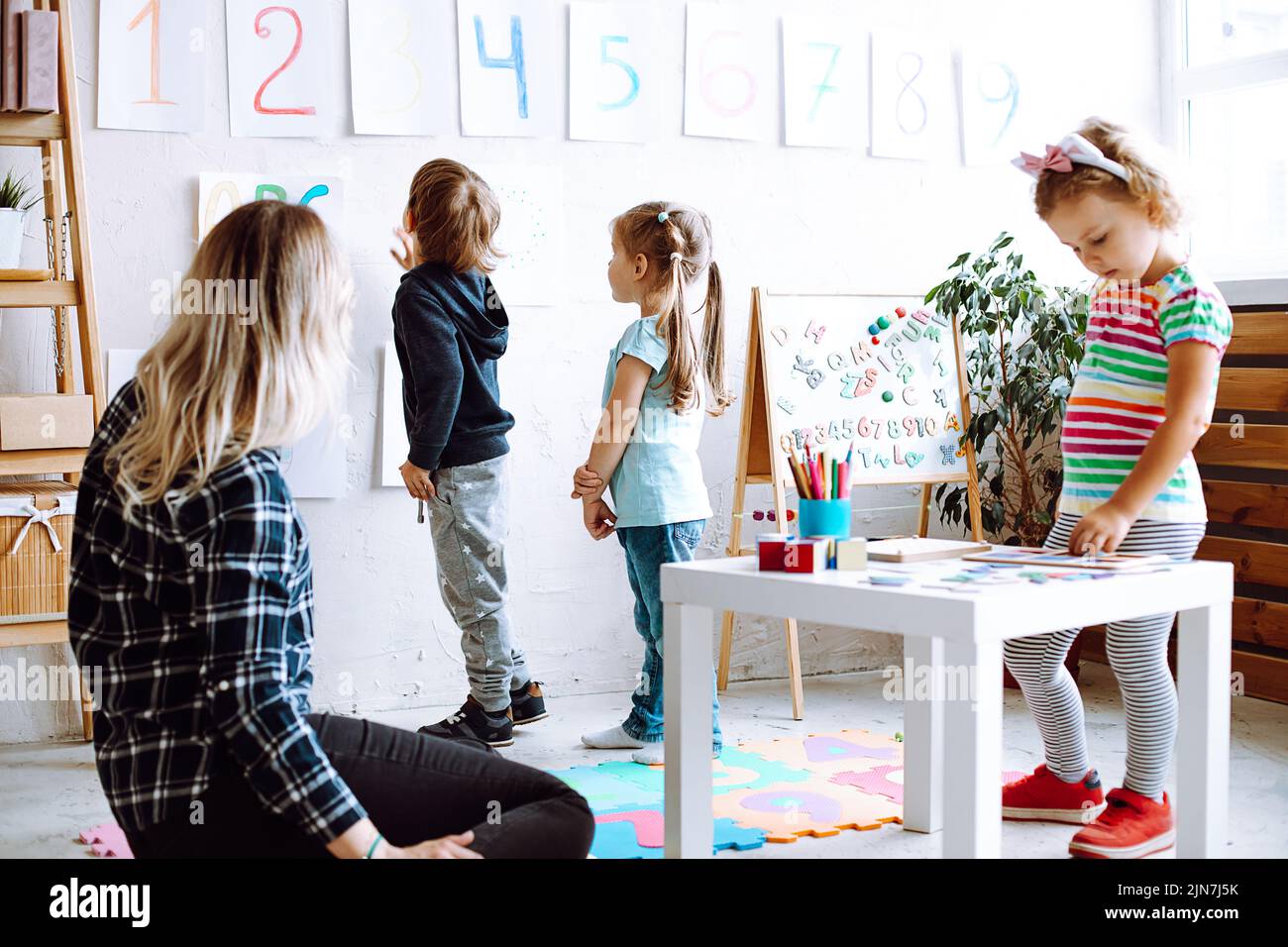 Group of adorable children pupils studying colorful numbers hung on ...