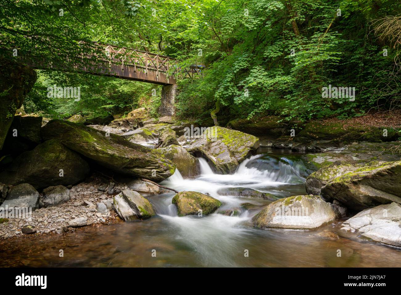 Long exposure of a waterfall flowing under a bridger on the East Lyn ...