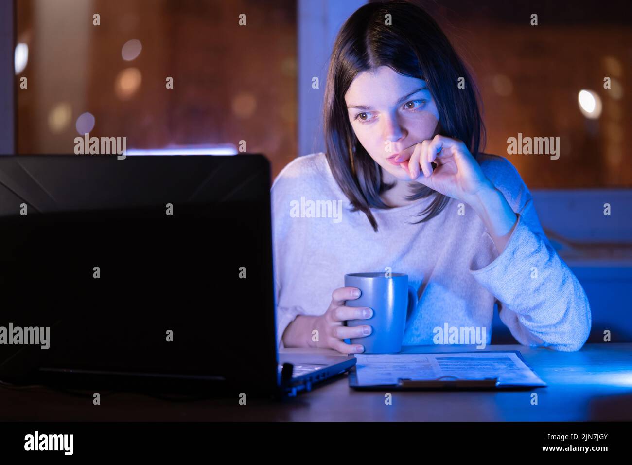 Girl is working, studying, using laptop at night Stock Photo - Alamy
