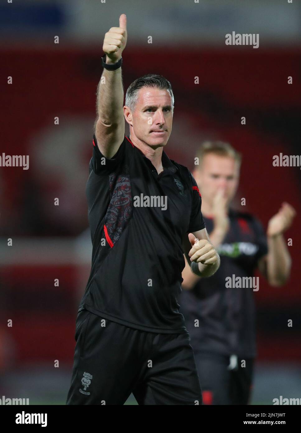 Lincoln City manager Mark Kennedy salutes the fans following the ...
