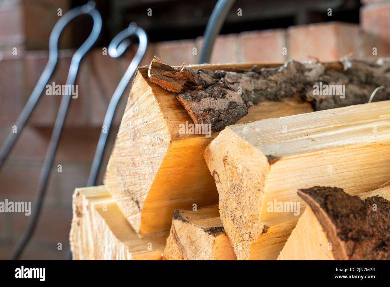 chopped firewood stacked in woodpile against background of fireplace ...