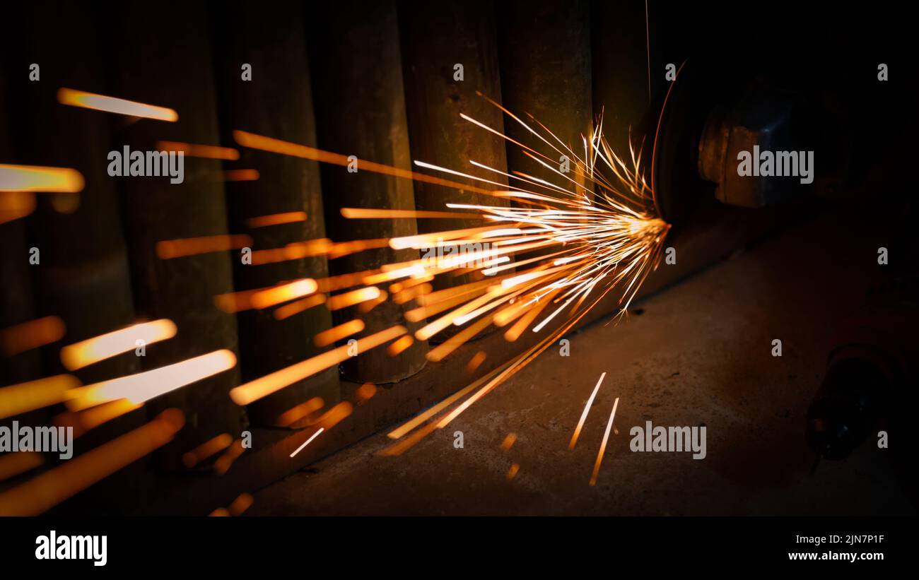 Flying sparks from an angle grinder being used in the dark Stock Photo ...