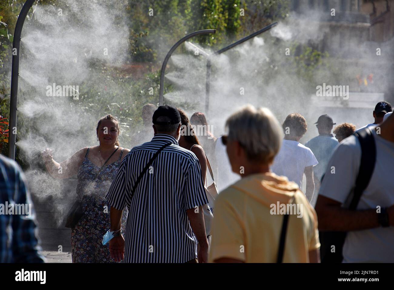 Marseille, France. 08th Aug, 2022. People pass under water sprayers in ...
