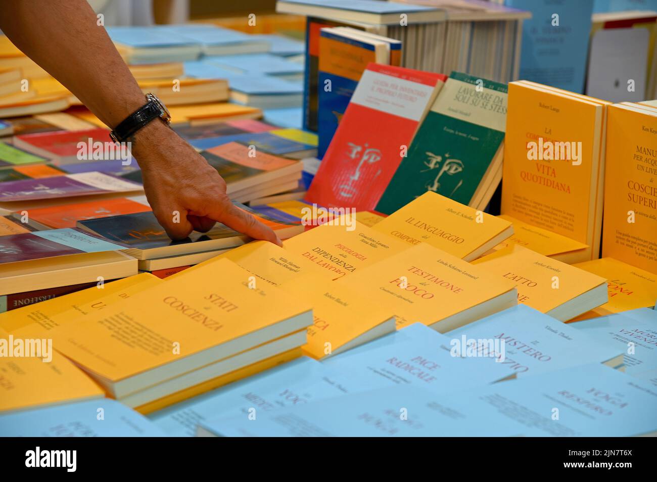 A man pointing to a book he chooses on the booth stall at the book fair ...