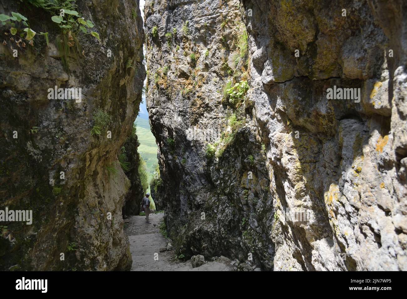 Girl walking down through the narrow stone path leading to the Malta ...