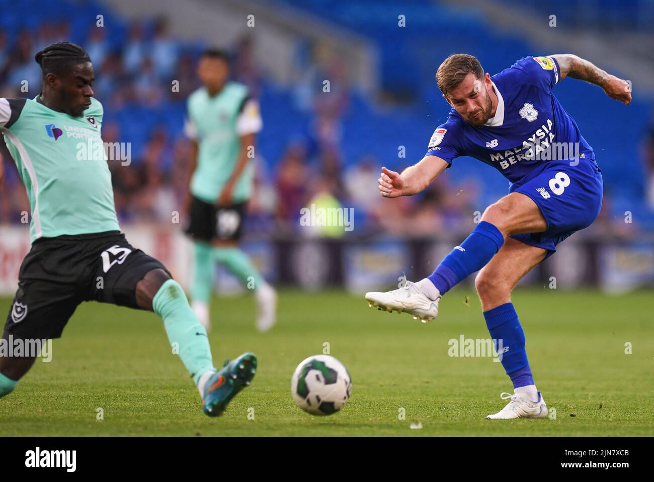 Joe Ralls #8 of Cardiff City shoots under pressure from Jay Mingi #25 ...