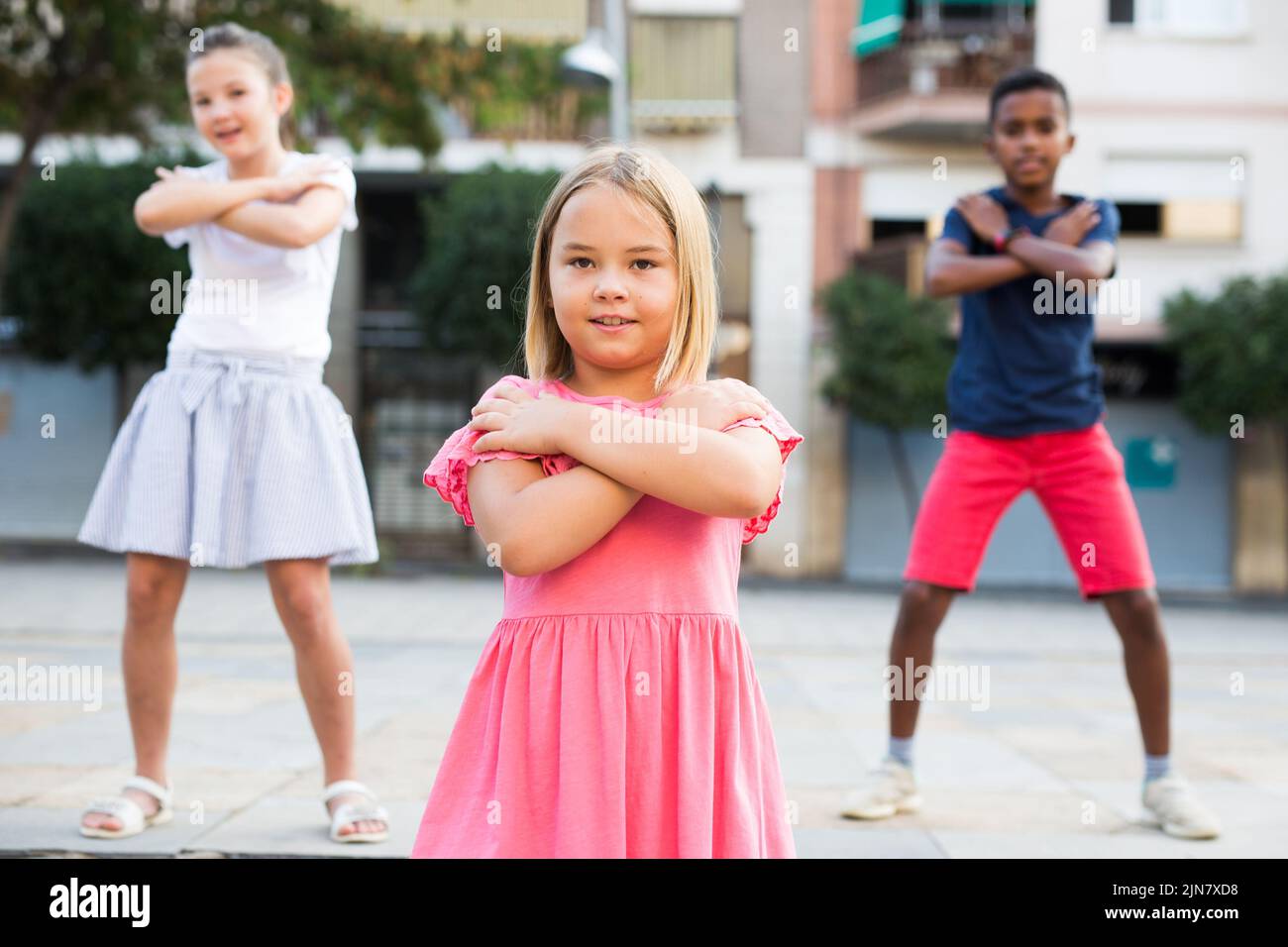 Preteen girl dancing with group of friends on city street Stock Photo ...
