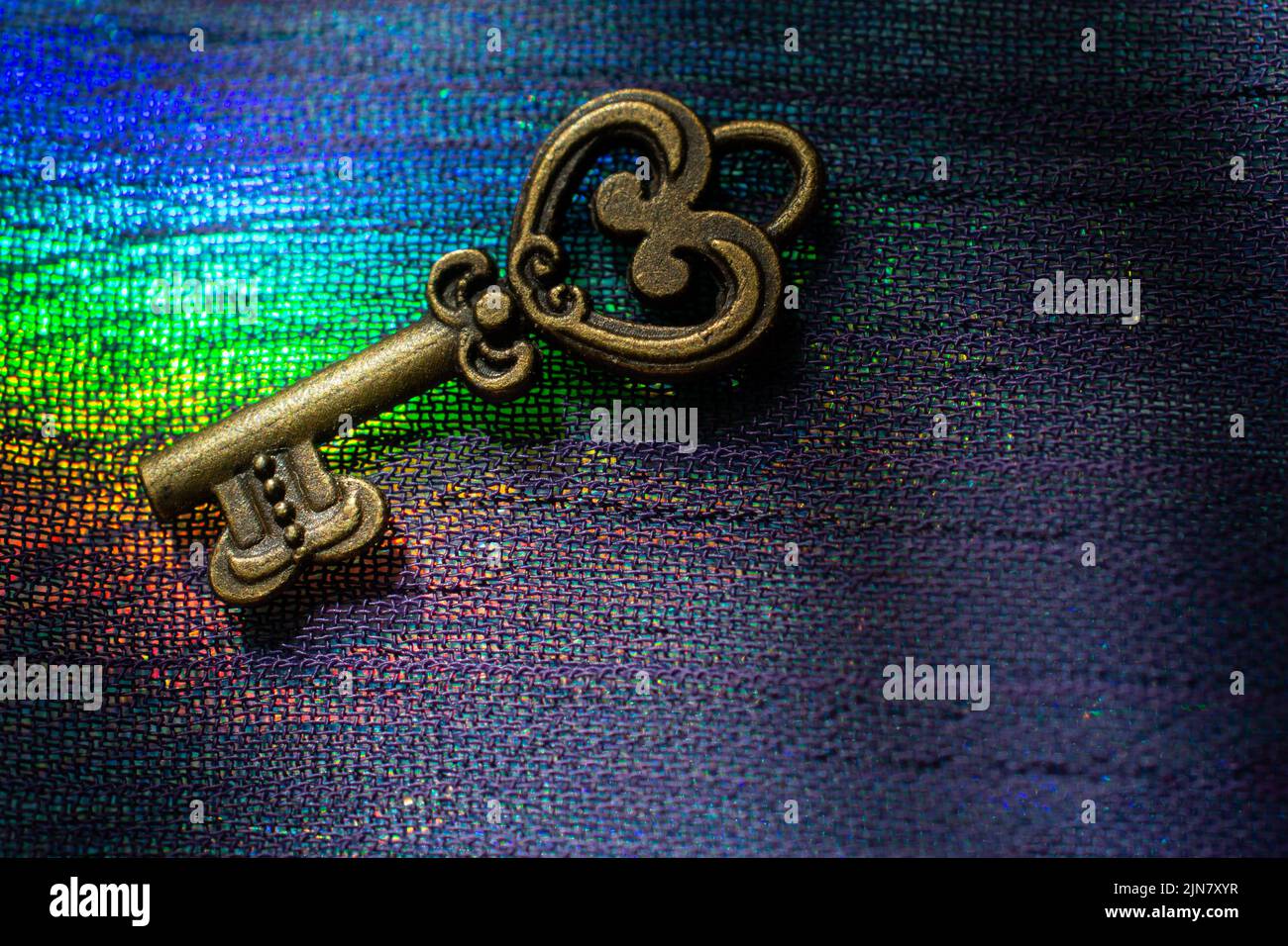Vintage key. .Antique key. Retro key on colorful fabric background ...