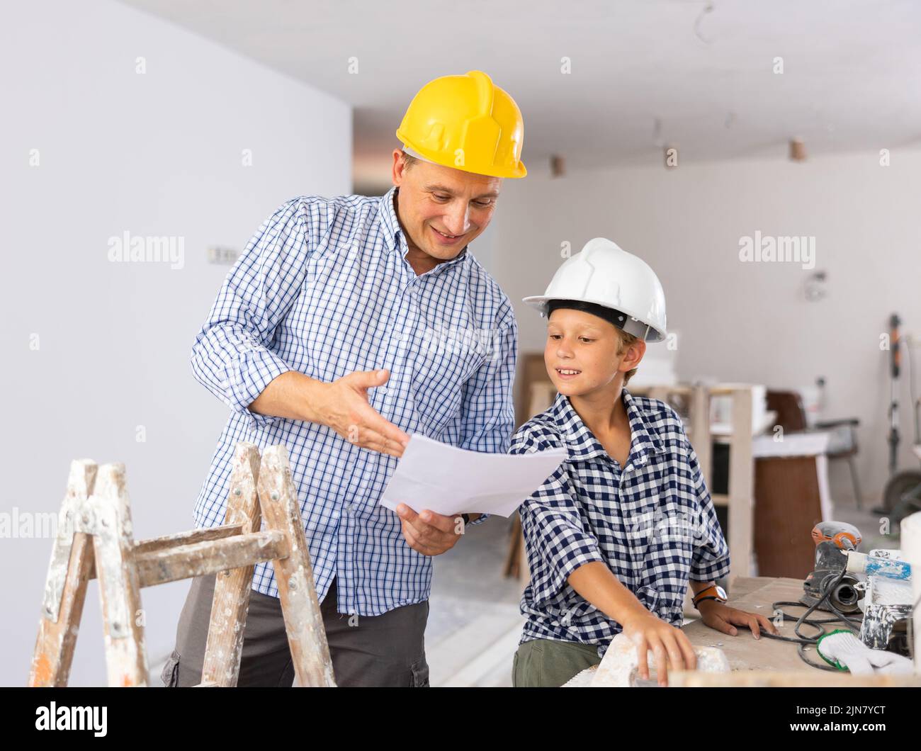 Man showing son blueprints in new home Stock Photo - Alamy