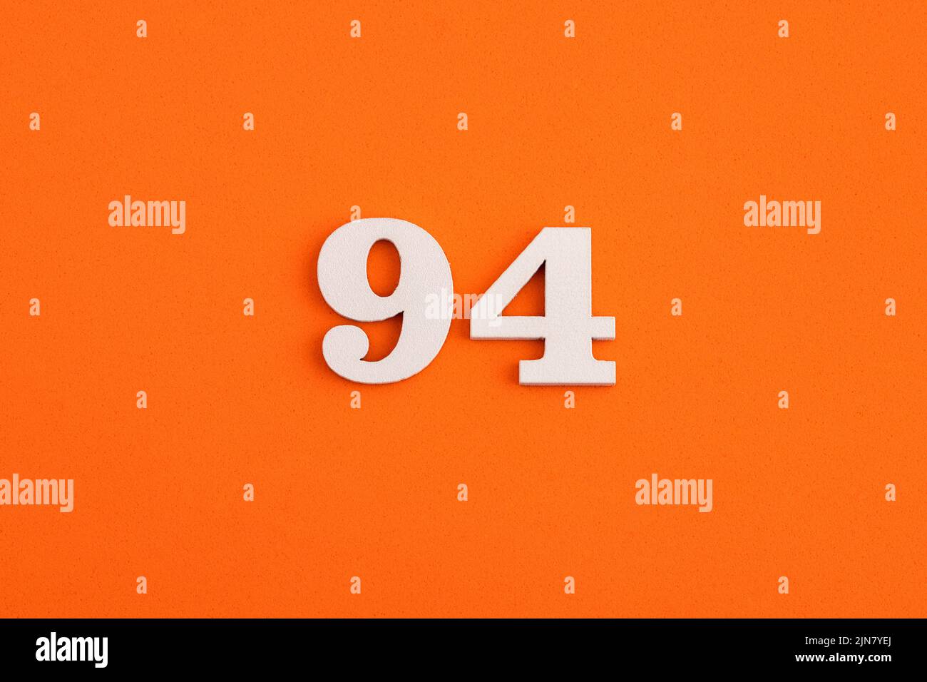 White wooden number 94 on eva rubber orange background Stock Photo - Alamy
