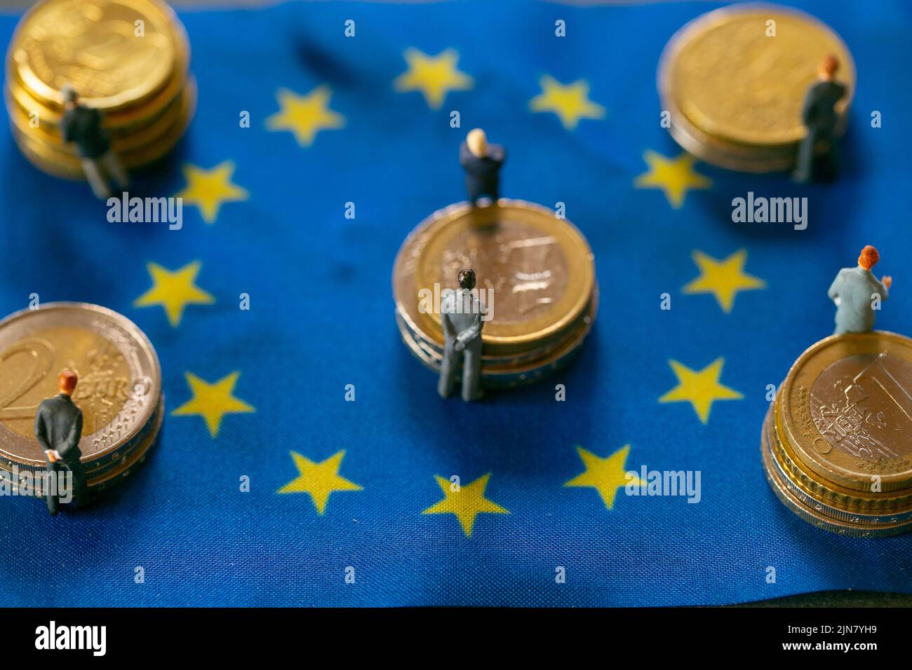 economy in in European countries.Figures of men in suits on euro coins ...