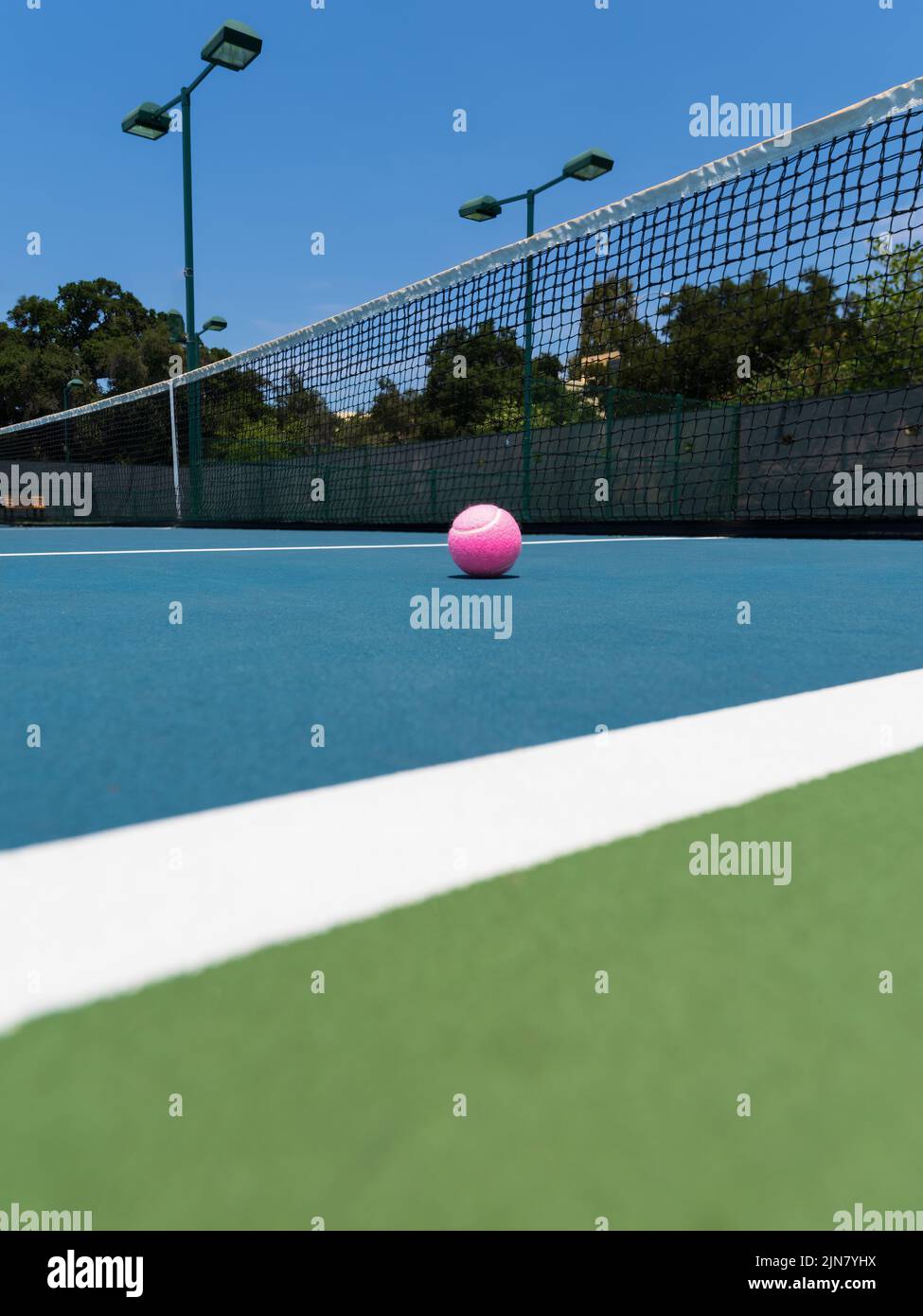 Pink tennis ball at rest on blue forecourt tennis court surface Stock ...