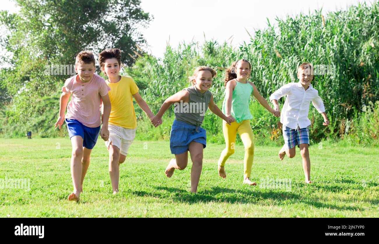 Group of five happy children jogging in a park Stock Photo - Alamy