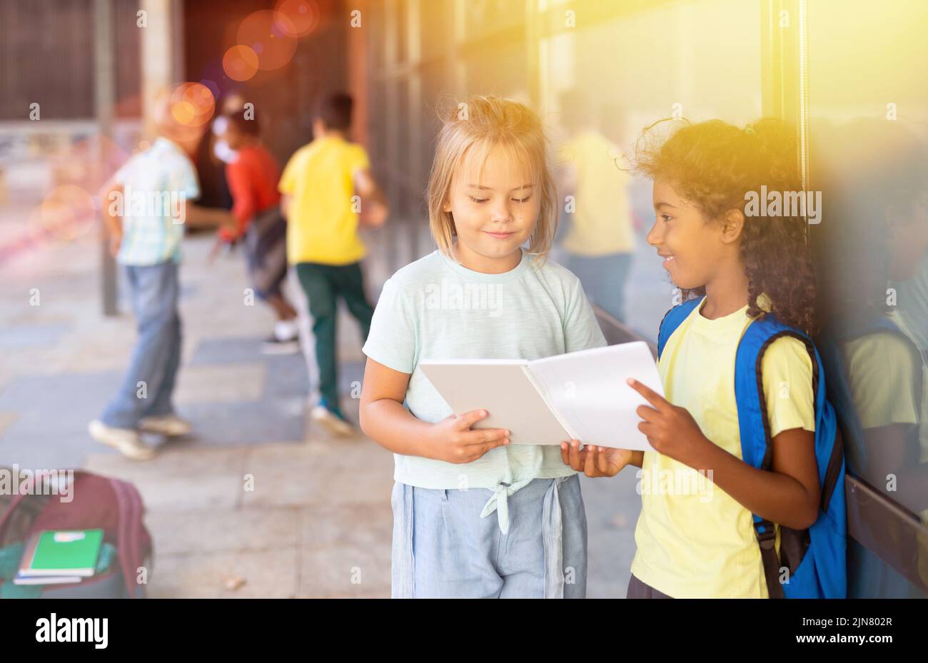 Two primary school girls talking outside Stock Photo - Alamy